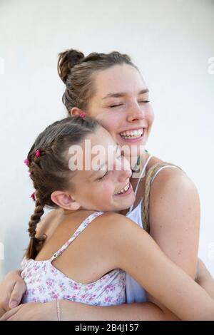 Sisters embracing, smiling, portrait Stock Photo - Alamy
