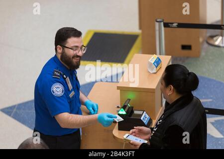 A TSA agent screens a passenger at a security checkpoint in the Central ...
