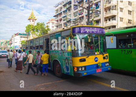 Myanmar, Burma. Yangon, Bus Stop on Sule Pagoda Road. The man and woman ...