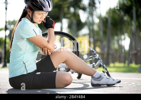 Girl girl fell off bike. Cyclist girl keeps self for bruised knee Stock ...