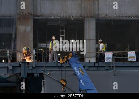 Construction workers on a half finished building during construction of ...