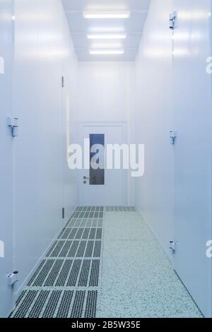 Inside white sterile cleanroom .Hallway with raised floor and door in ...