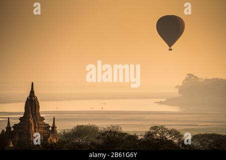 Bagans temples in sunrise with hot air balloons in the sky, Bagan ...