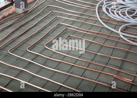 Bent new copper pipes laying on concrete floor Stock Photo - Alamy