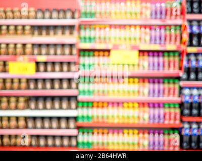 Female customer choosing soft drinks in grocery store, looking at ...