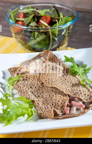 a Breton crepe with cheese and bacon in white plate Stock Photo - Alamy