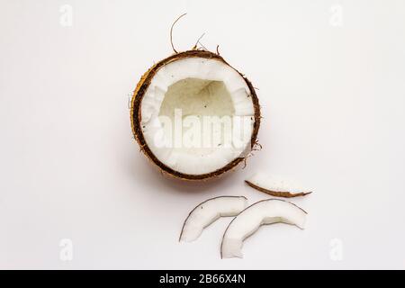 Ripe coconut cut on two half isolated on bright blue marine background ...