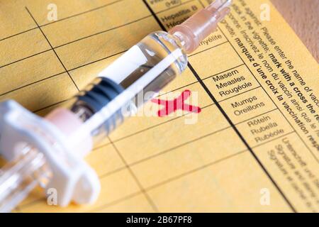 Measles vaccination, vaccination card, syringe with measles vaccine ...