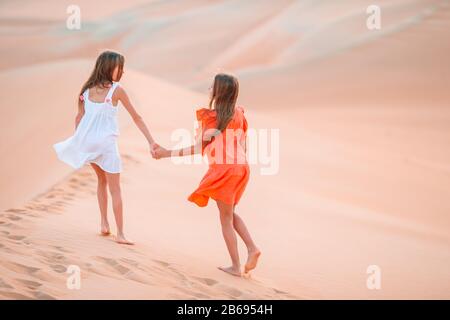 Girls among dunes in big desert in Emirates Stock Photo - Alamy