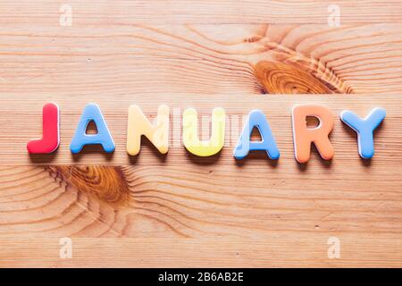 Wooden letters written January month on vintage background. Inscription ...