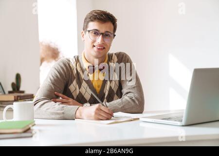 Portrait of attractive cheery guy writing text gambling having fun ...