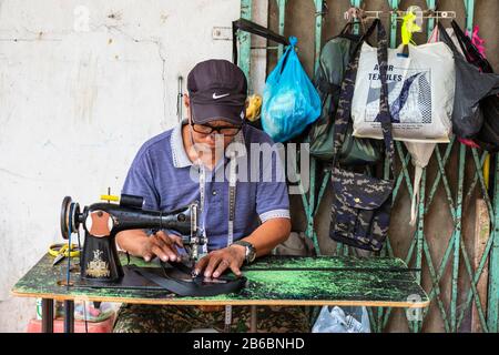 tailor man using a leather sewing machine Stock Photo - Alamy