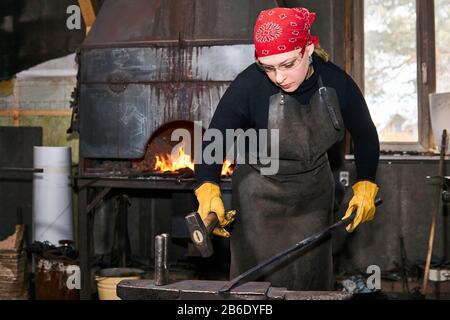 Woman blacksmith working in a forge, Much Hadham, Herfordshire, England ...