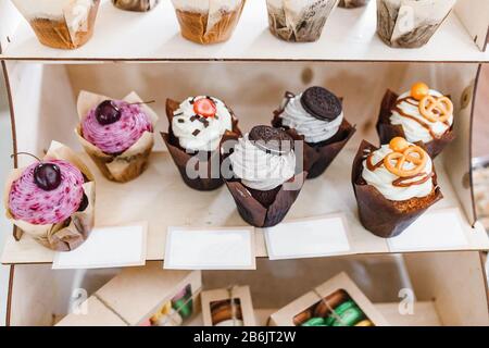 Selling cupcakes and muffins at the showcase in candy shop Stock Photo ...