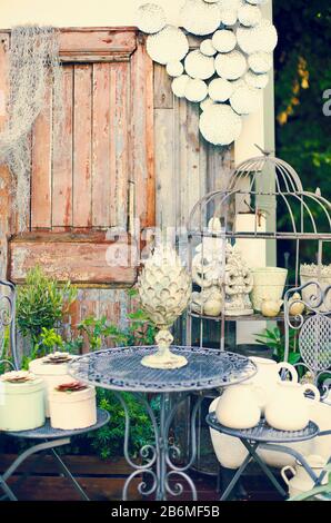 Shabby wooden table with chairs and vase located near comfortable couch ...