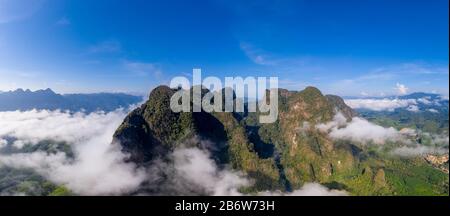 Tropical mountain with jungle forest trees plants clouds and blue sky ...