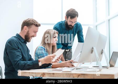 smiling employees checking financial statements . business concept ...
