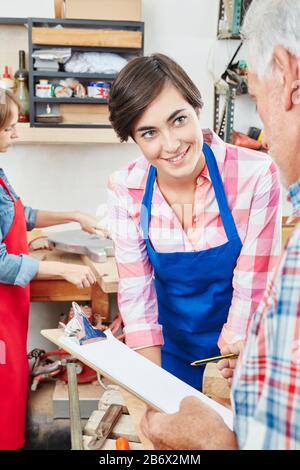 Young woman during craftsman internship lesson Stock Photo - Alamy