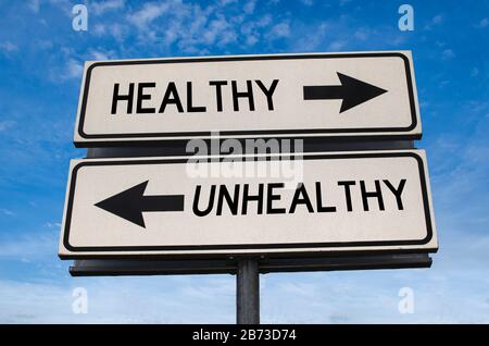 Healthy or unhealthy road sign on blue sky background Stock Photo - Alamy