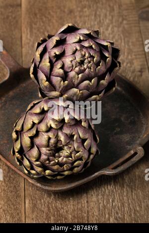 Artichokes on wooden table Stock Photo - Alamy