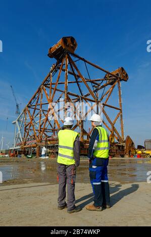 Construction workers in front of an offshore oil and gas platform also ...