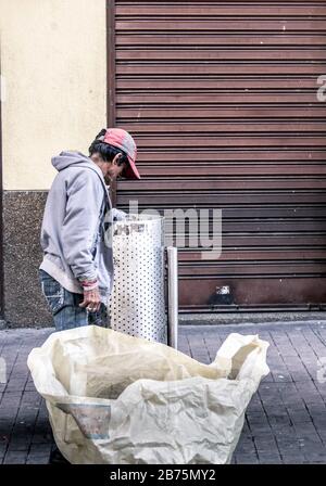 Homeless man digging in a garbage dumpster for food Stock Photo - Alamy