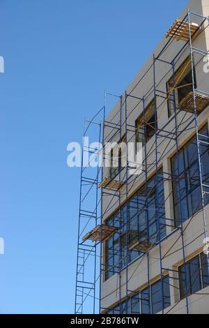 Scaffolding round building with sky at background Stock Photo - Alamy