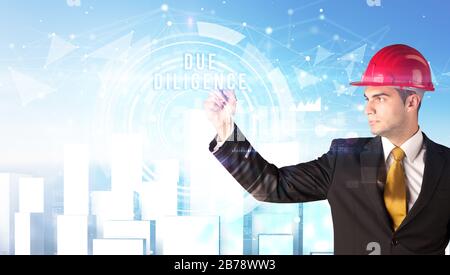 Handsome businessman with helmet drawing DUE DILIGENCE inscription ...