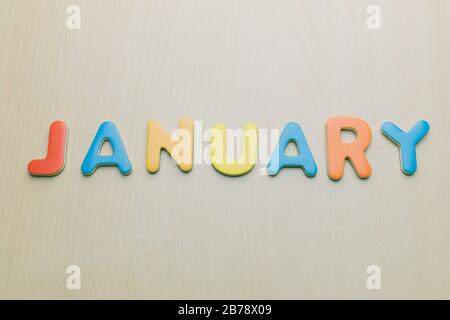 Wooden letters written January month on vintage background. Inscription ...