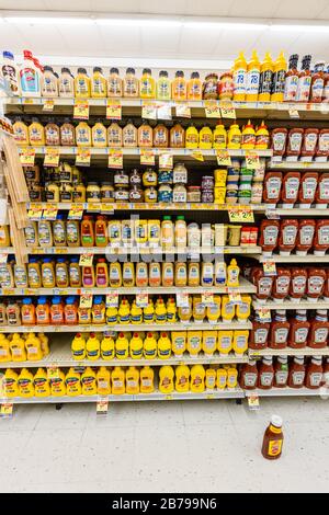 Assorted brands of yellow mustard sauce bottles fully stocked on ...