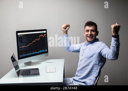 Happy young trader in formalwear and eyeglasses shouting and feeling ...