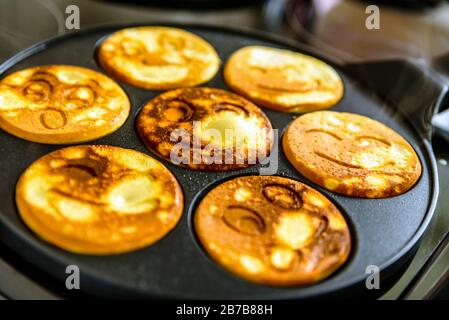 pancake frying pan with smile face pancake cooking on cooker in kitchen ...
