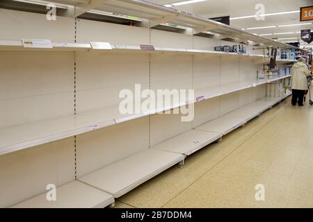 Toilet paper rolls in a supermarket trolley on a gray background ...