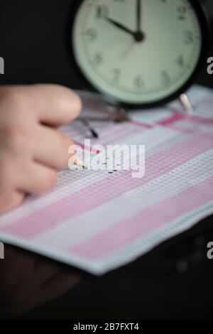 Person filling in a checklist next to a table watch - time management ...