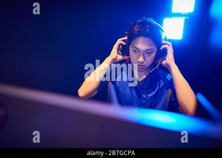 Professional gamer with headset starting to play online video game in ...