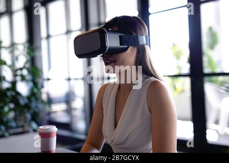 Asian woman using virtual reality headset in modern office for future ...