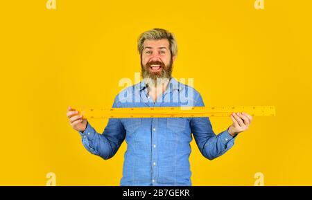 Measuring with ruler. School teacher hold ruler yellow background ...