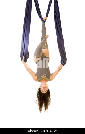 Aerial performer in colorful suit gracefully swings over a calm sea at ...
