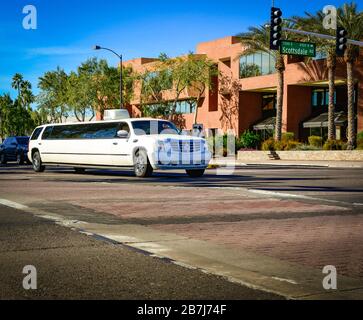 A white Cadillac stretch limousine, crossing an intersection at ...