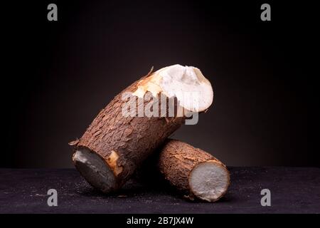 Unprepared Cassava roots with textured bark and white edible inside ...