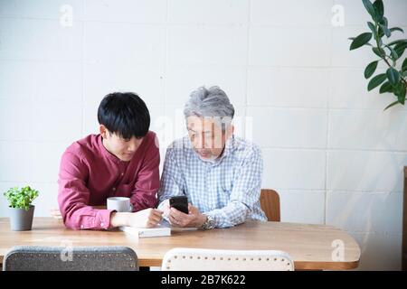 Senior instructed smartphone by young man Stock Photo - Alamy