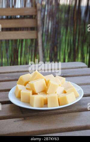 A closeup shot of a block of Camembert cheese on a wooden board with ...