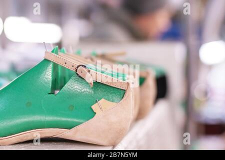 The conveyor on a shoes factory with shoe and sole. Mass production of ...