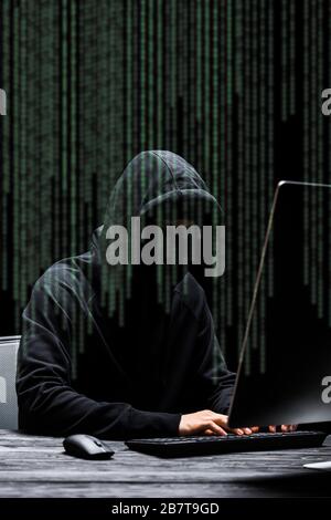 hacker in mask sitting near computer monitors and cyber security ...