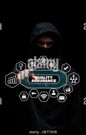 selective focus of hacker in hood pointing with finger at padlock ...