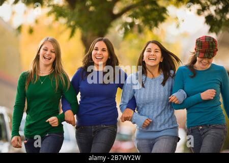Girls linking arms and walking Stock Photo - Alamy
