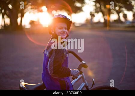 One caucasian children rides bike road in autumn park. Little girl ...