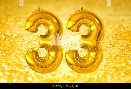 Gold number 33 (number thirty-three) with laurel branch with alpha ...