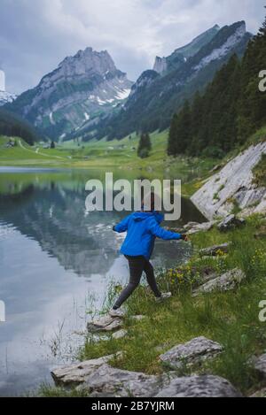 Young woman in blue jacket jogging in park Stock Photo - Alamy