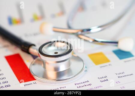 Stethoscope and US dollar banknotes on chart or graph paper, Financial ...